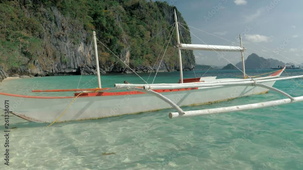 Close-up shot of traditional filipino bangka boat anchored on gorgeous ...