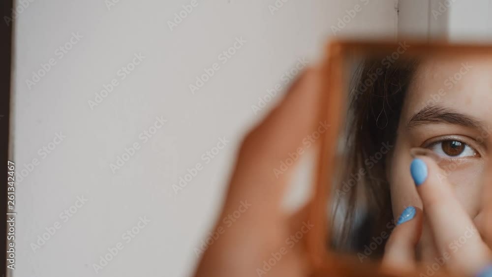 Vídeo do Stock: Reflection in the mirror of a beautiful young girl who ...
