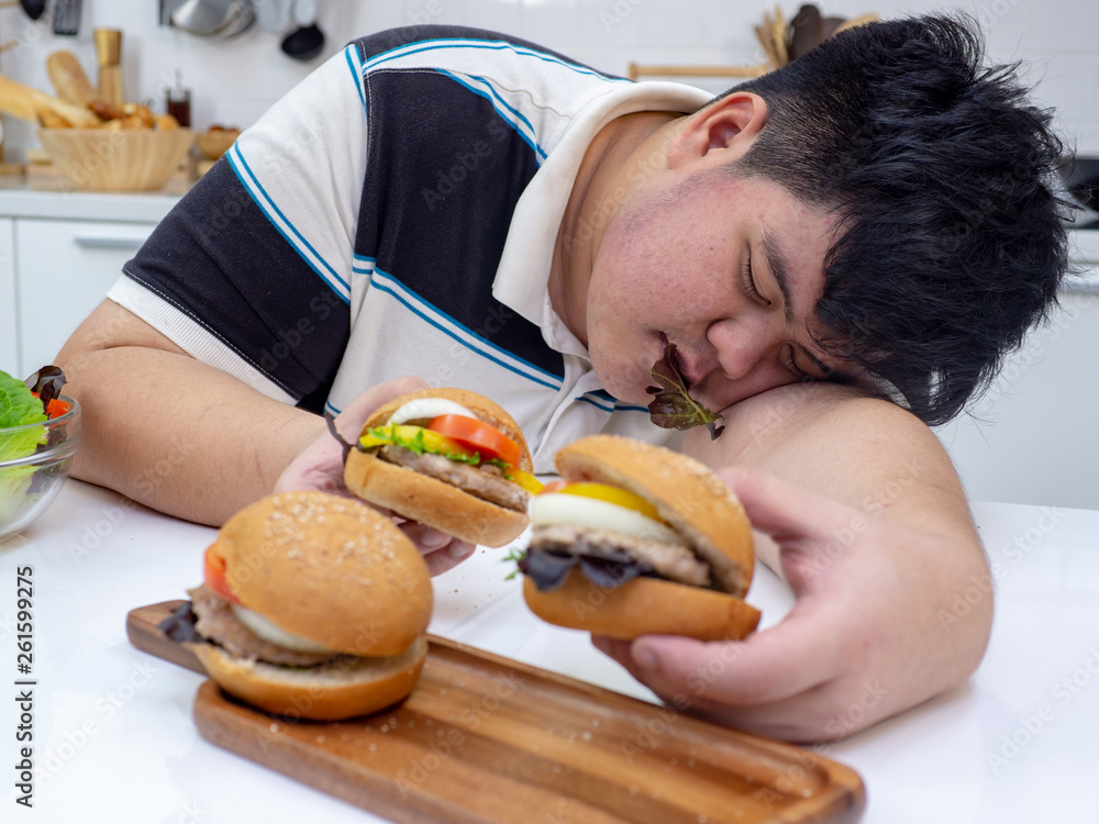 young Asia fat man happy when he eating unhealthy food or junk food ...