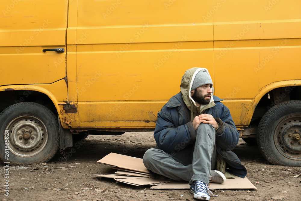Poor homeless man sitting near van outdoors Stock Photo | Adobe Stock