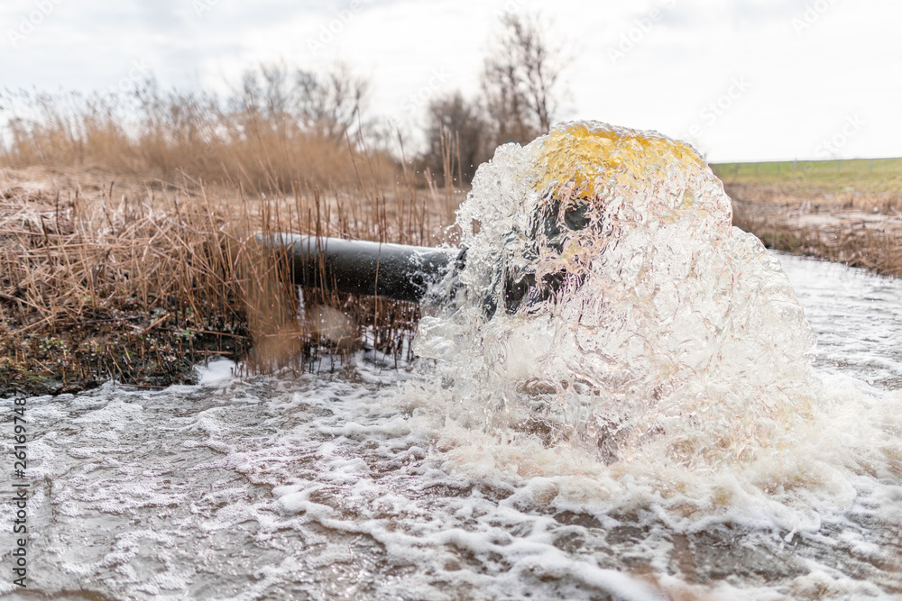 schmutziges Wasser fließt aus einem Abflussrohr in den Fluss und ...
