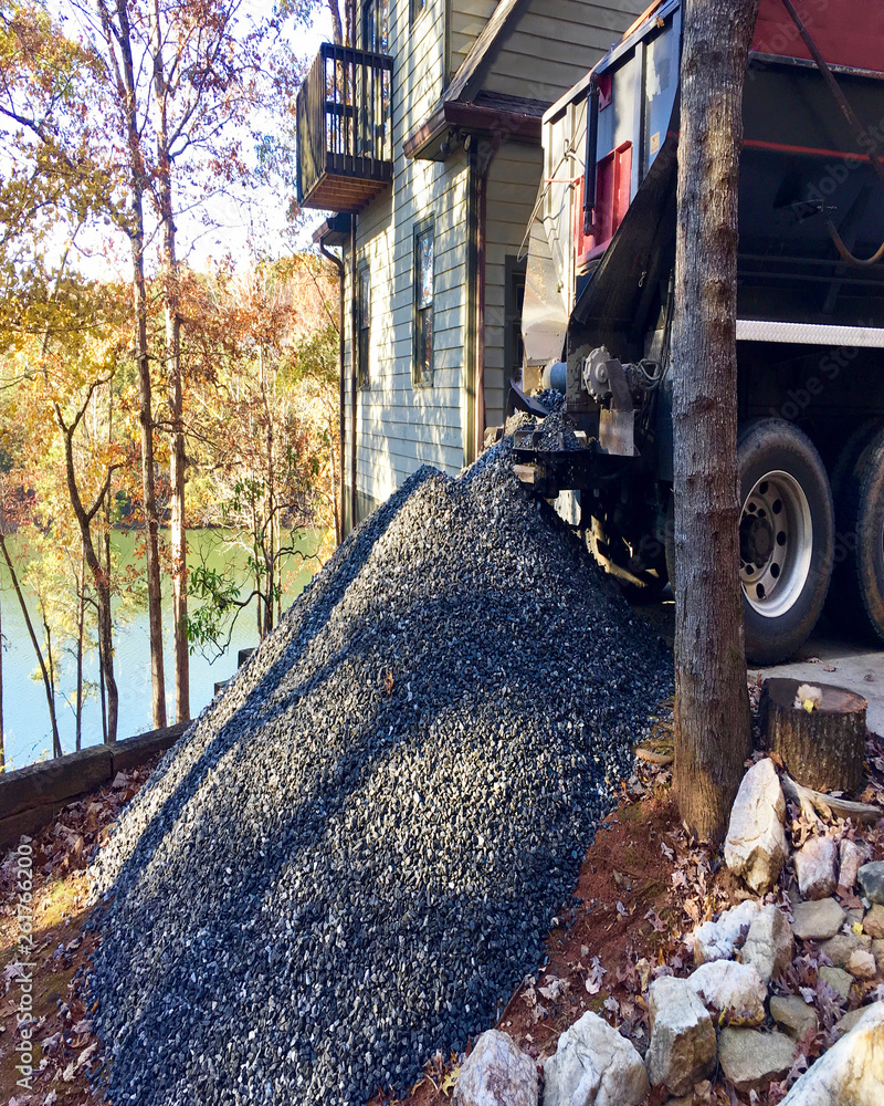 Dump truck delivering gravel to a job site. Stock Photo | Adobe Stock