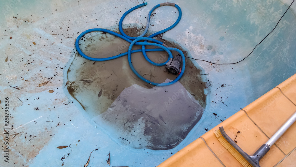 Bottom of drained swimming pool with just a little dirty water around ...