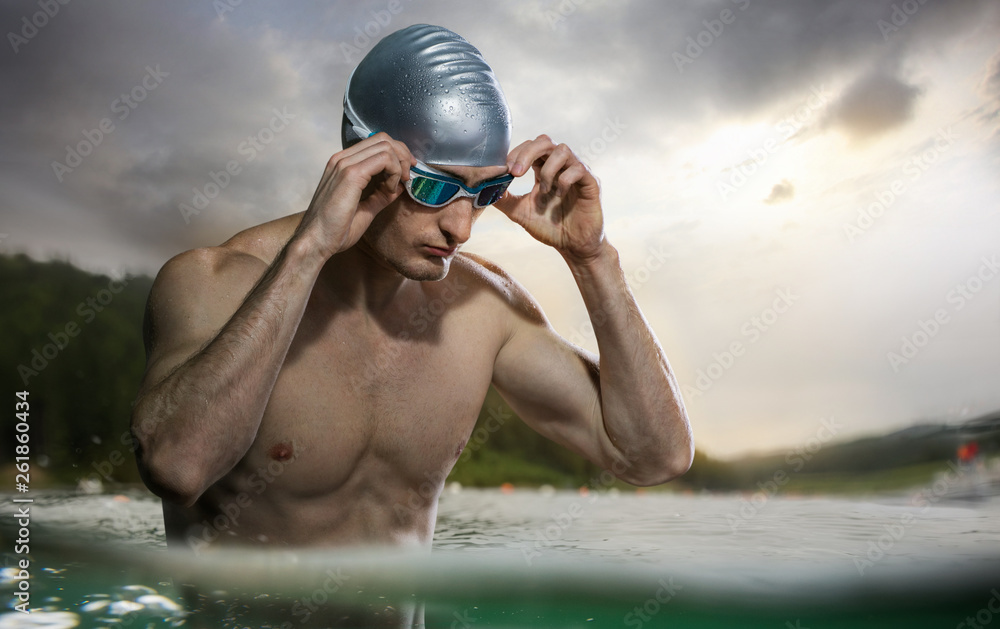 Sport backgrounds. Young athletic swimmer standing near the sunset ...