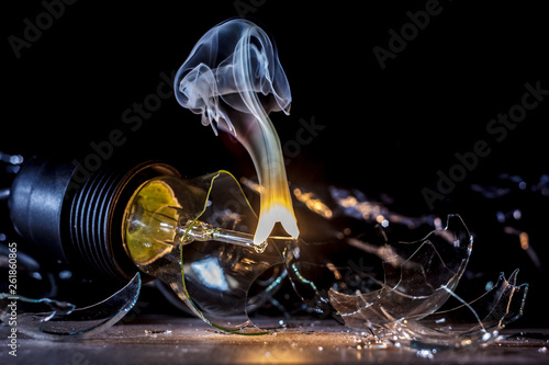 Amazing explosion of burning light bulb with splinters of broken glass ...