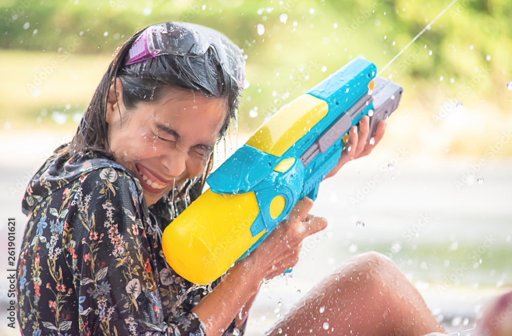 Asian woman holding a water gun play Songkran festival or Thai new year ...