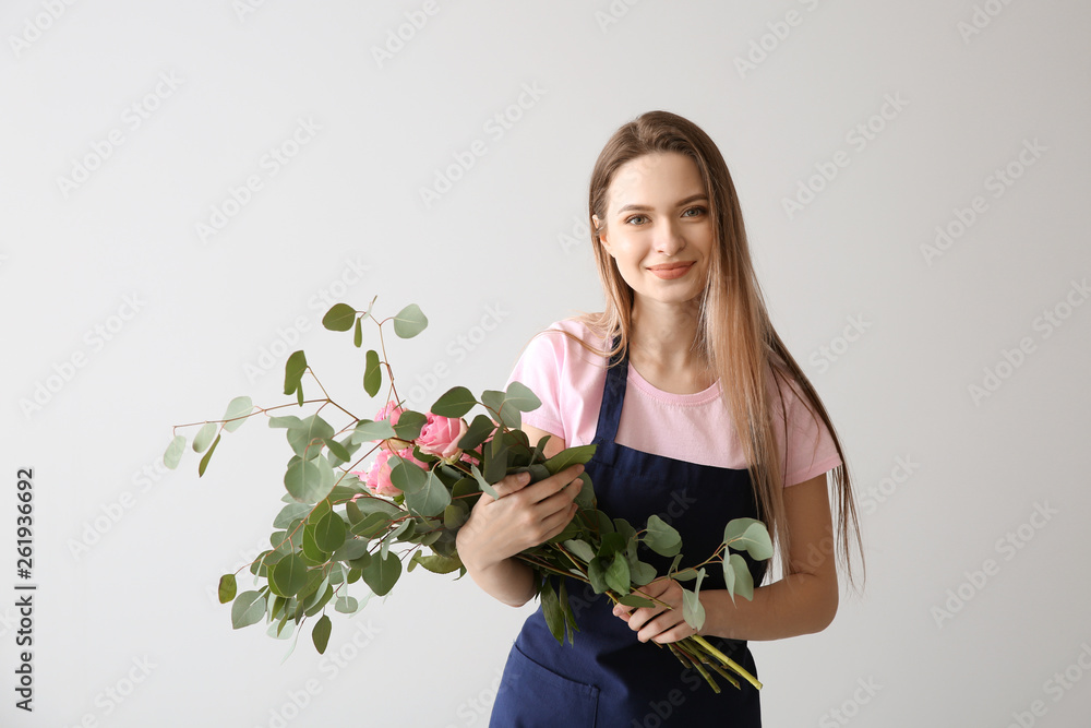 Florist with bouquet against light background Stock Photo | Adobe Stock
