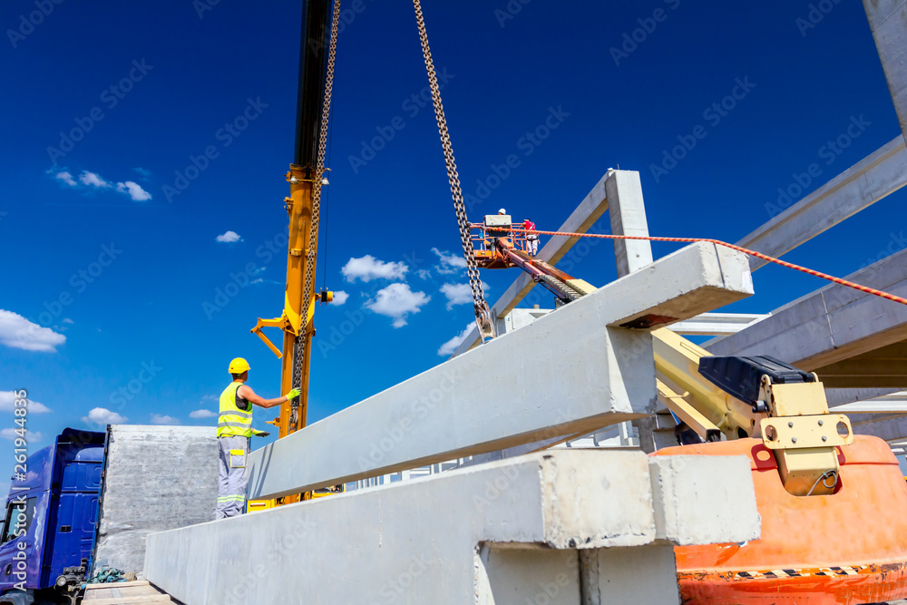 Unloading concrete pillar from truck trailer at construction ...