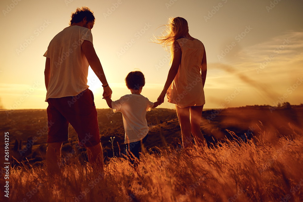 Rear view of family standing in nature at sunset Stock Photo | Adobe Stock