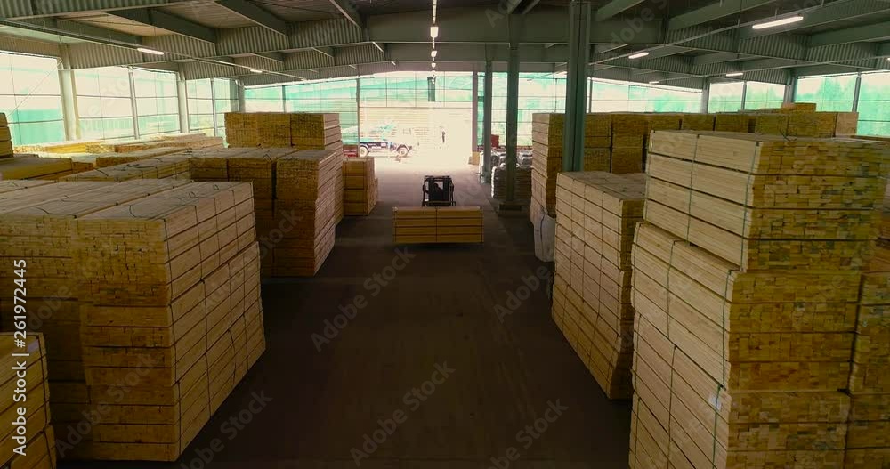 A forklift carries a wooden beam through the sawmill's warehouse ...