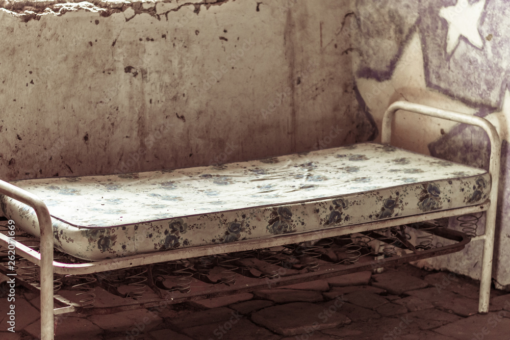 Photograph of a very old bed, made only of metal structure and where ...