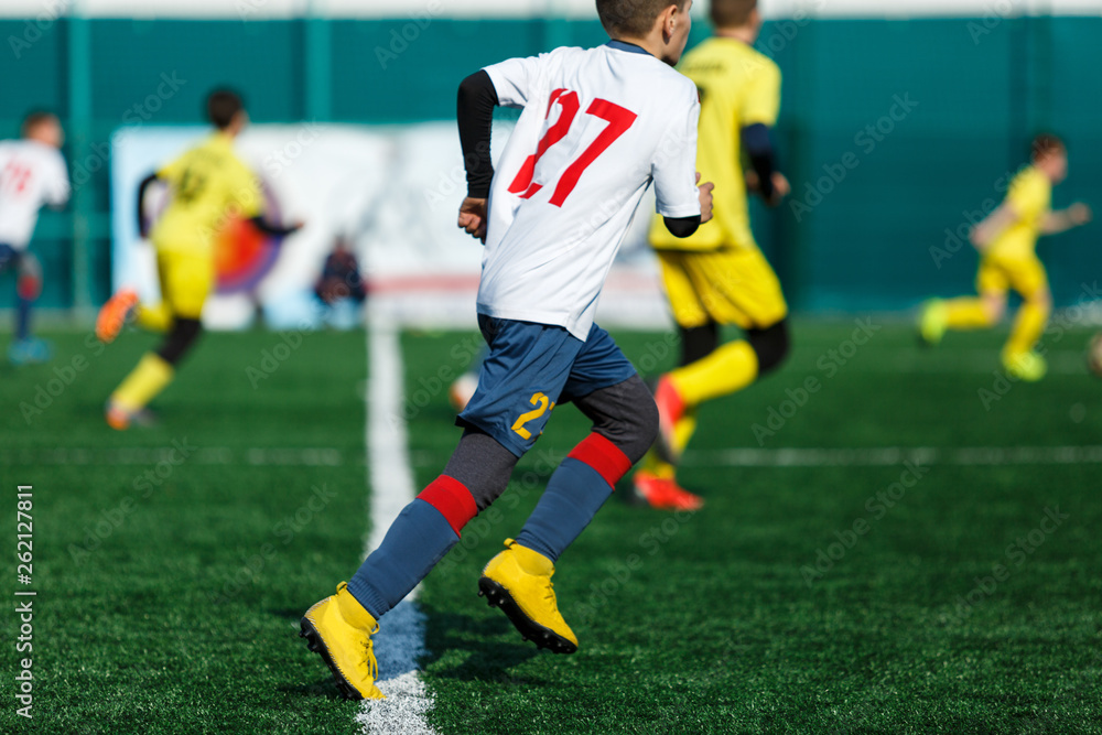 Boys in yellow white sportswear running on soccer field. Young ...