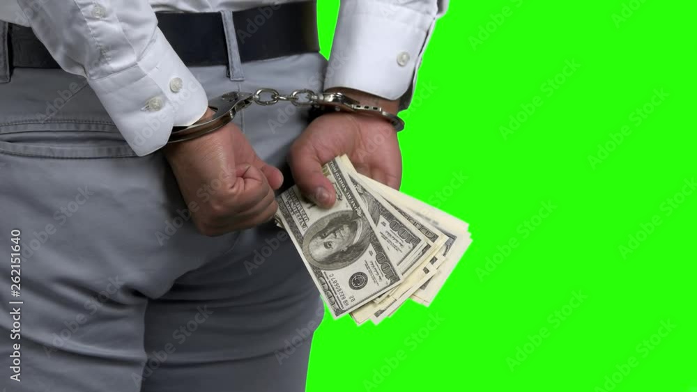 Man in handcuffs holding money, back view. Businessmans hands in ...