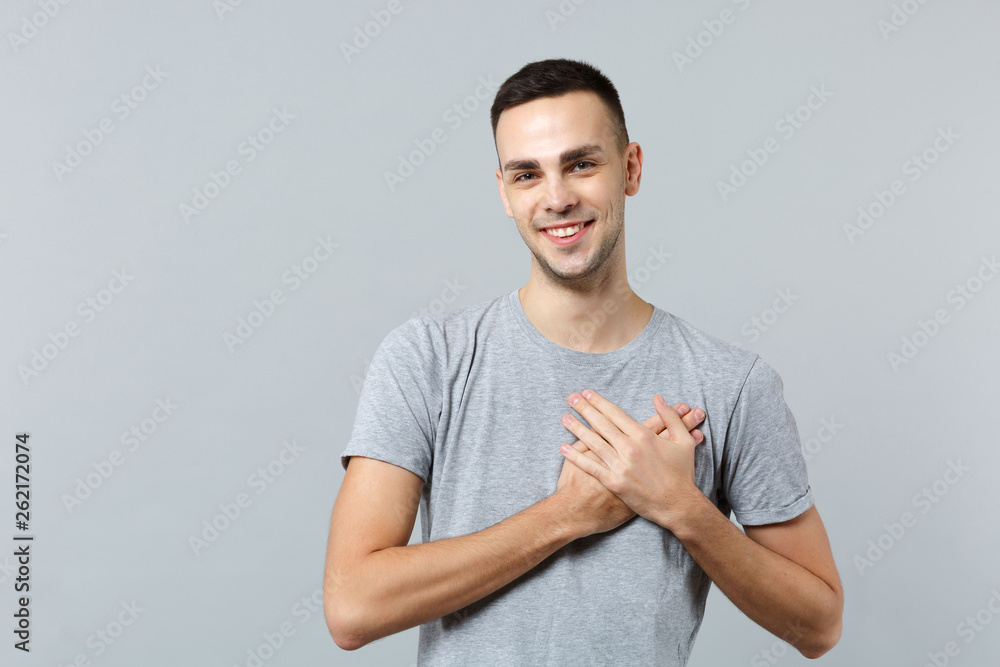 Smiling pleasant young man in casual clothes looking camera, holding ...