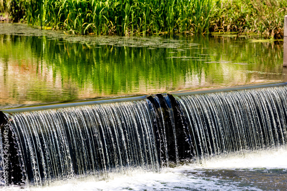 Water cascade streaming down from small dam, water saving ecology ...
