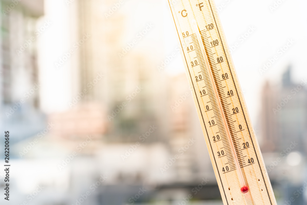 Thermometer against the city with hot weather background. Global ...