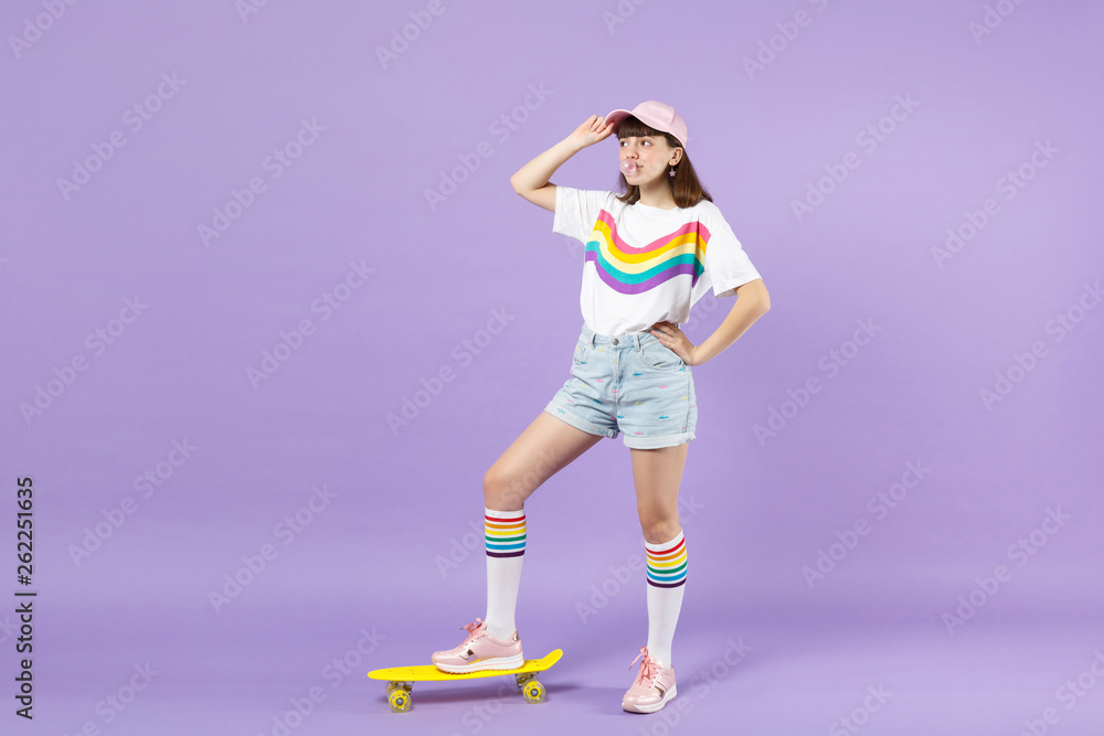 Cute teen girl in vivid clothes standing with yellow skateboard ...
