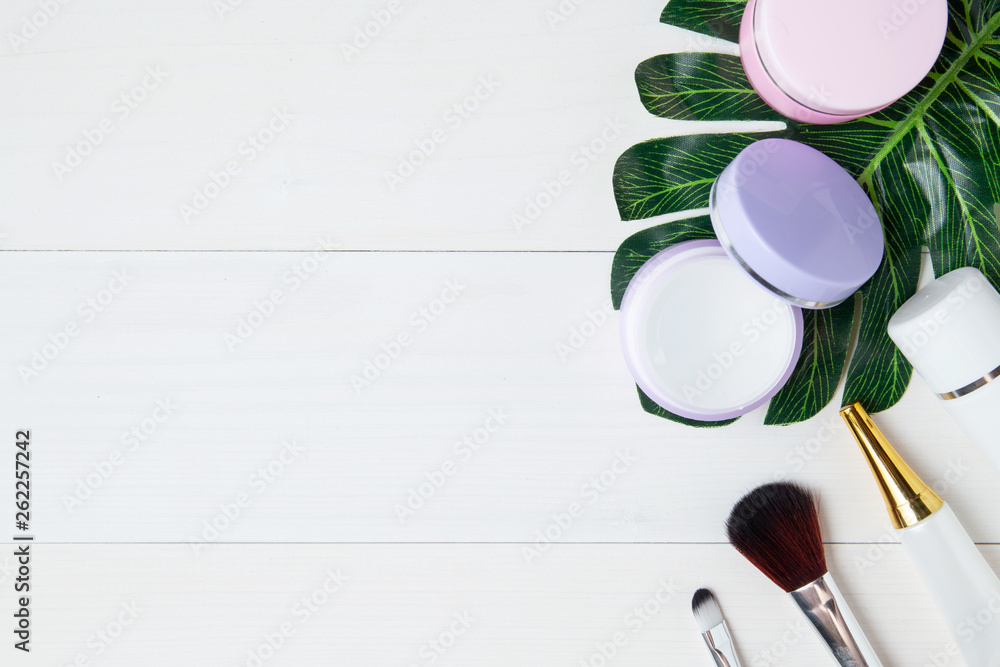 cosmetic and skin care product and green leaves on white wood table ...