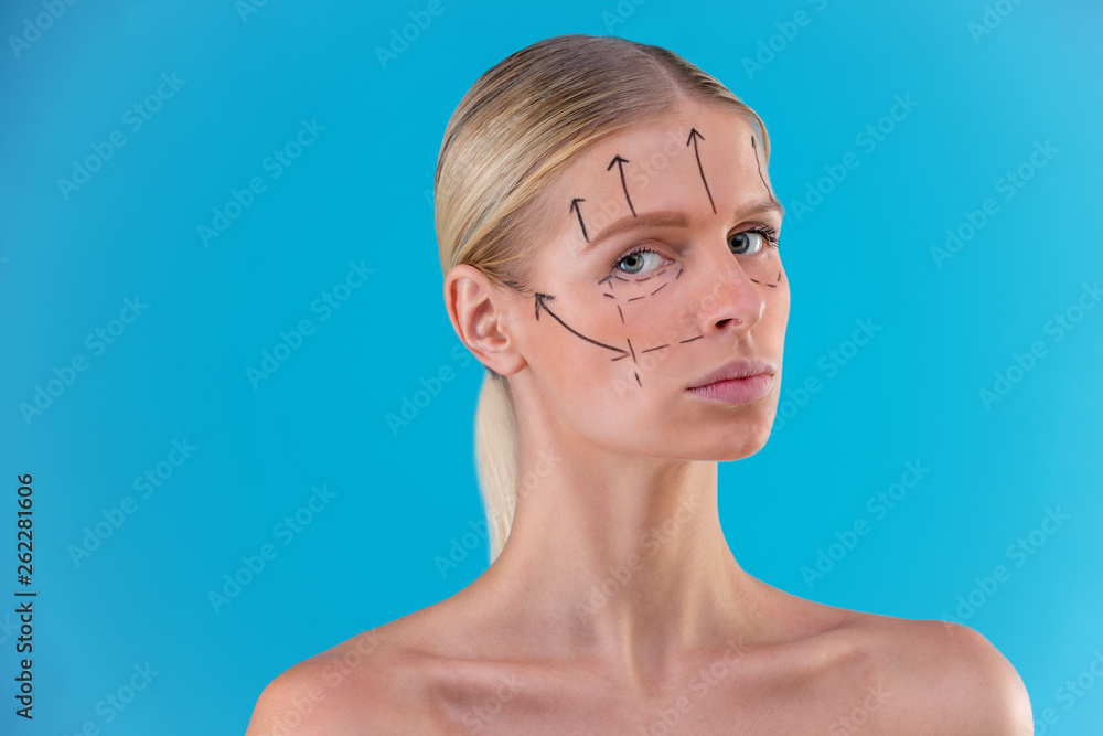 Beautician draw correction lines on woman face. Before plastic surgery ...