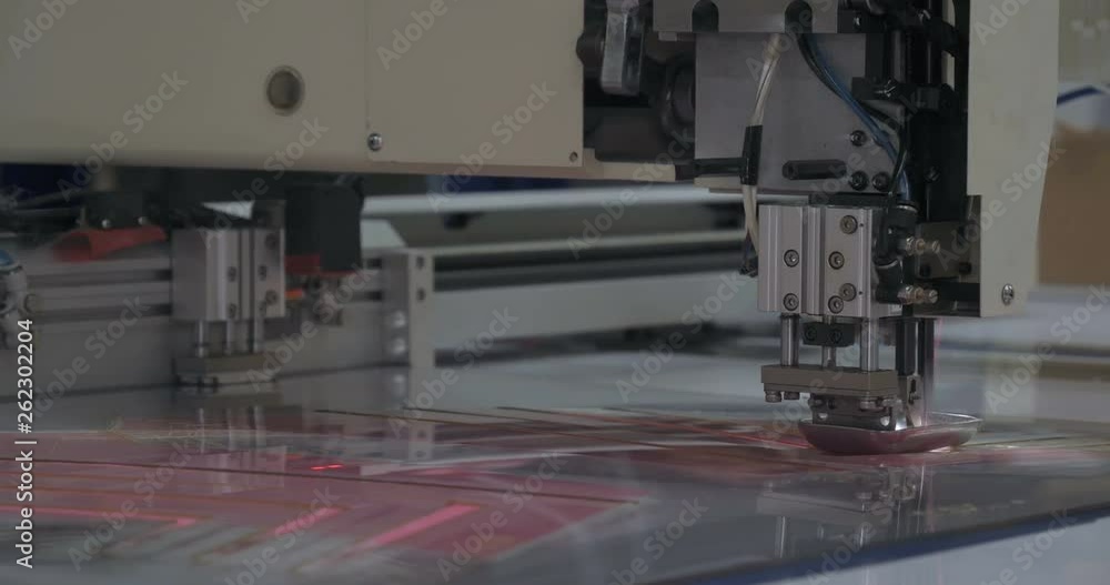 In an industrial garment factory, an automatic sewing machine sews ...