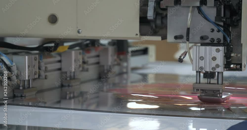 In an industrial garment factory, an automatic sewing machine sews ...