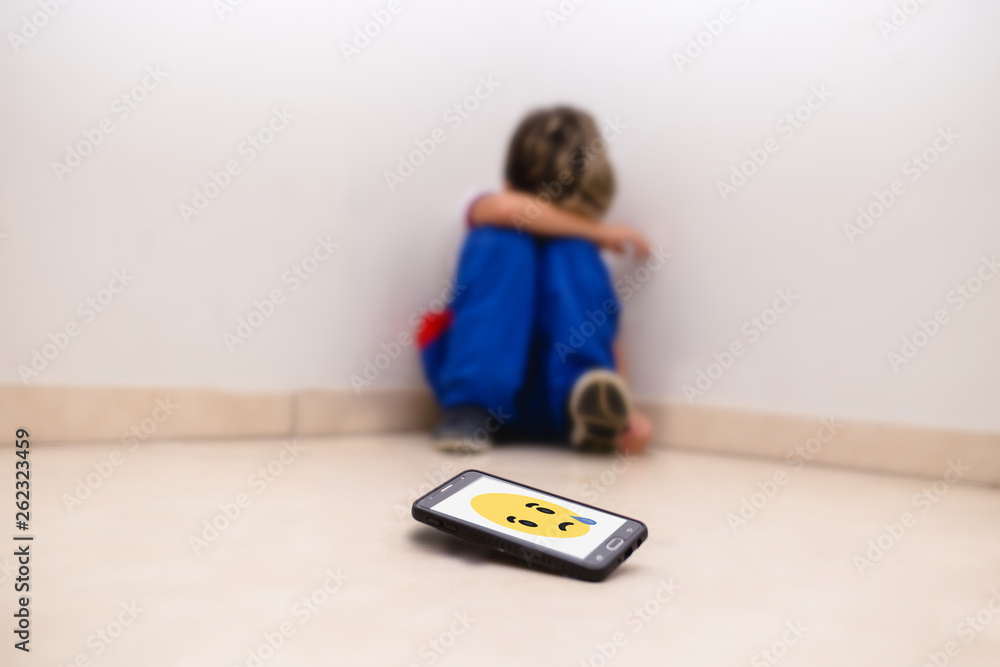 concept of cyber bulling. Child in school uniform crying in front of ...