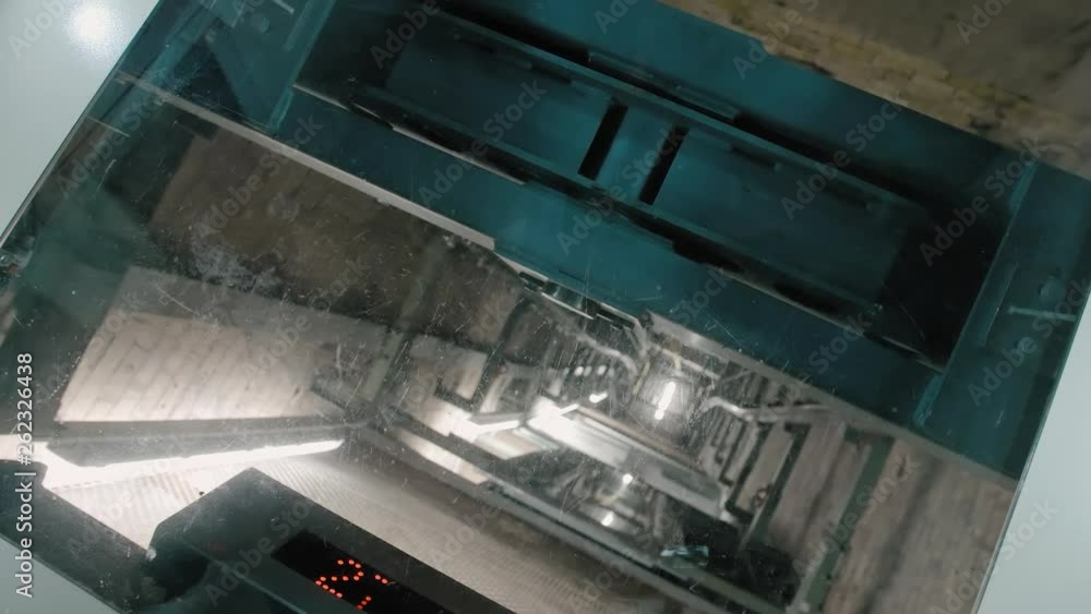 Curved elevator shaft. A downward elevator with a transparent glass top ...