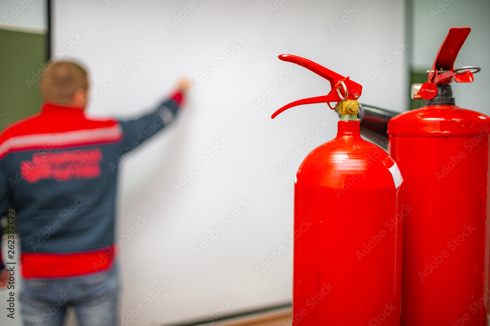 Uniformed fireman gives a lecture or instruction on fire safety. The ...