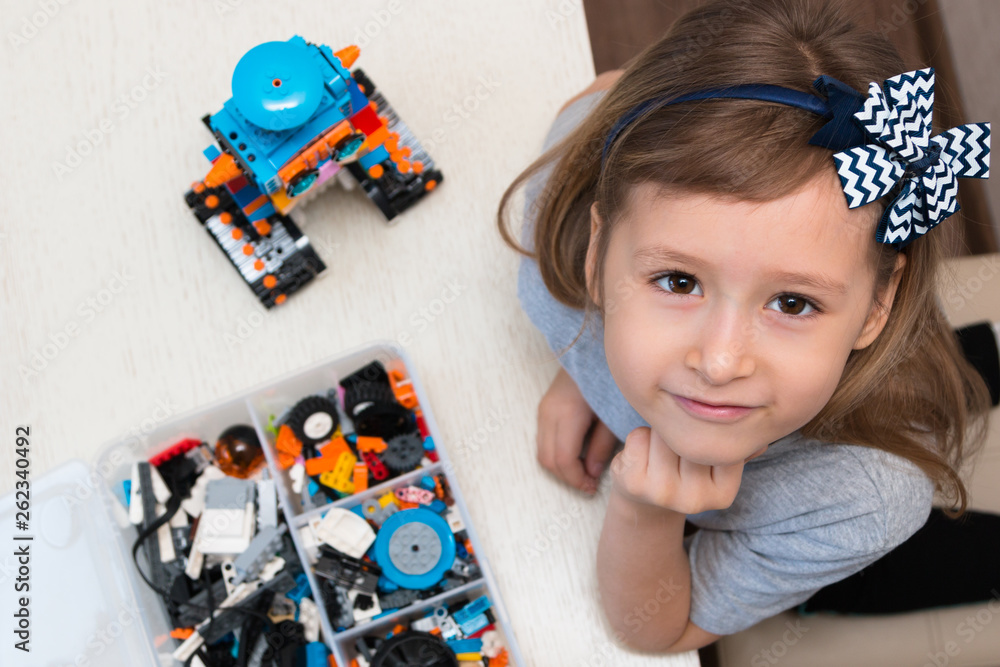 STEM and STEAM education. Cute little girl code robot in the class of ...