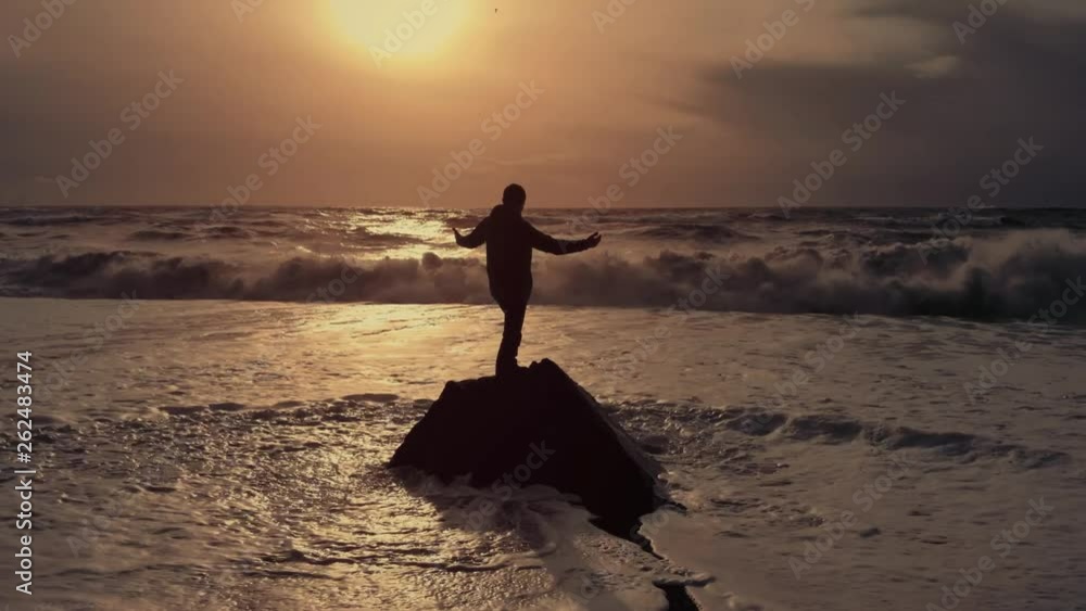 Video „Man stands in the silence of the ocean, stretching his hands to ...