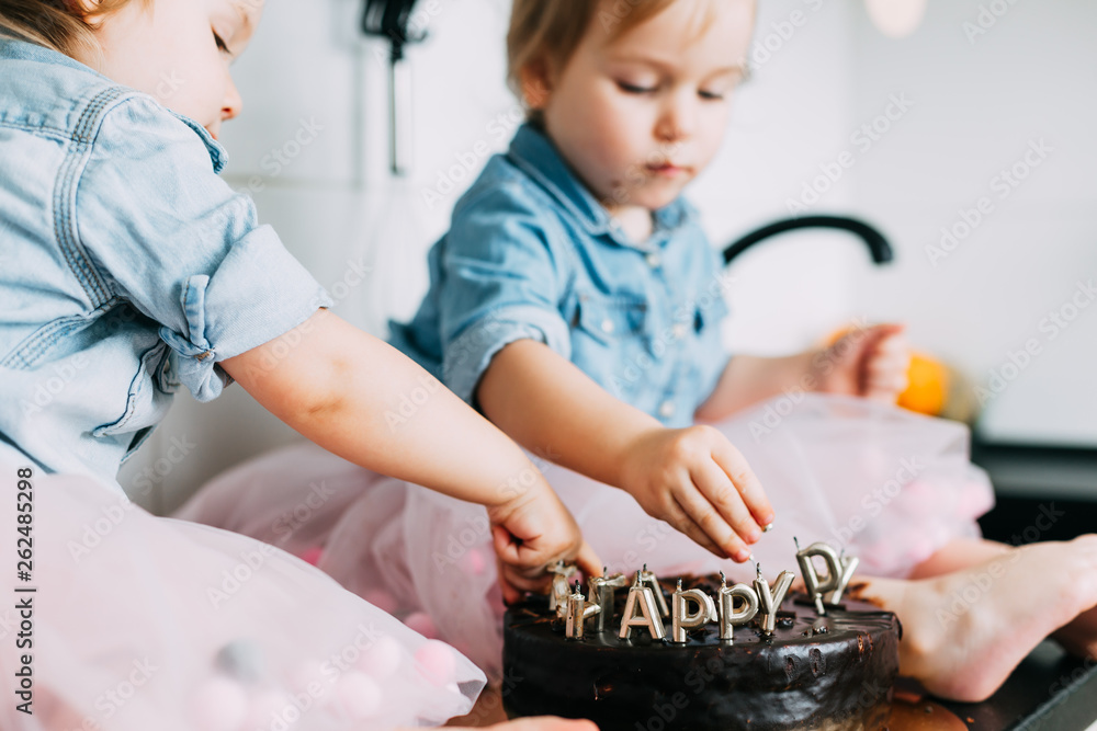 two little twin girls celebrate their birthday. eating chocolate cake ...