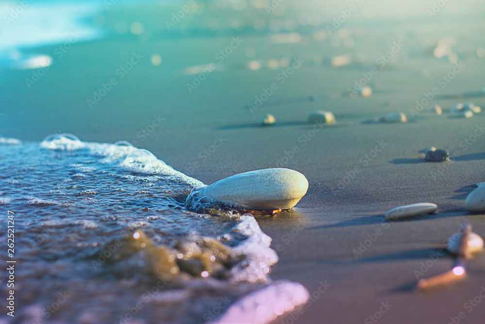 Sand at the Beach and cooming foamy wave. One white big stone on the ...