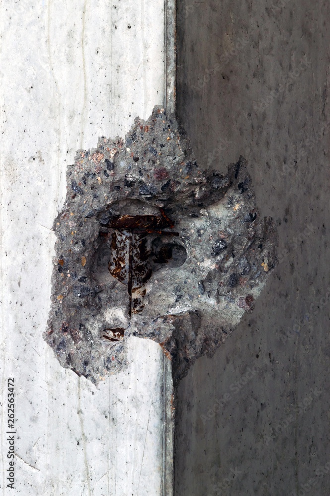 broken corner of a concrete column, a thick rod of iron reinforcement ...