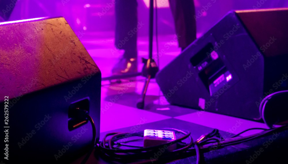 Stage monitor speakers and cables in purple ambient light at band live ...