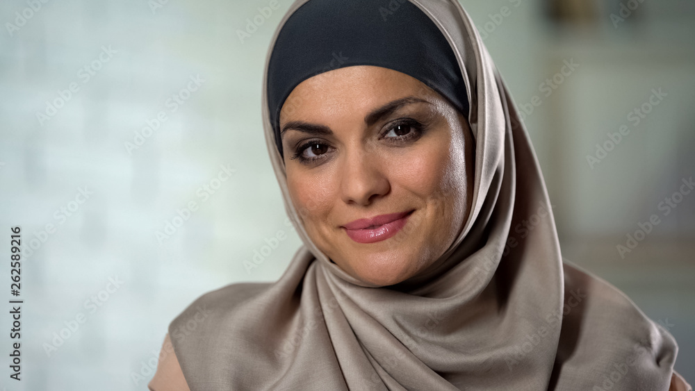 Modest muslim woman in hijab looking at camera with mysterious smile ...