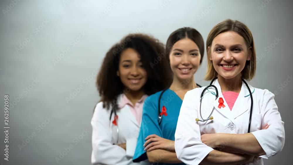 Smiling multiracial doctors with red ribbons, international AIDS ...