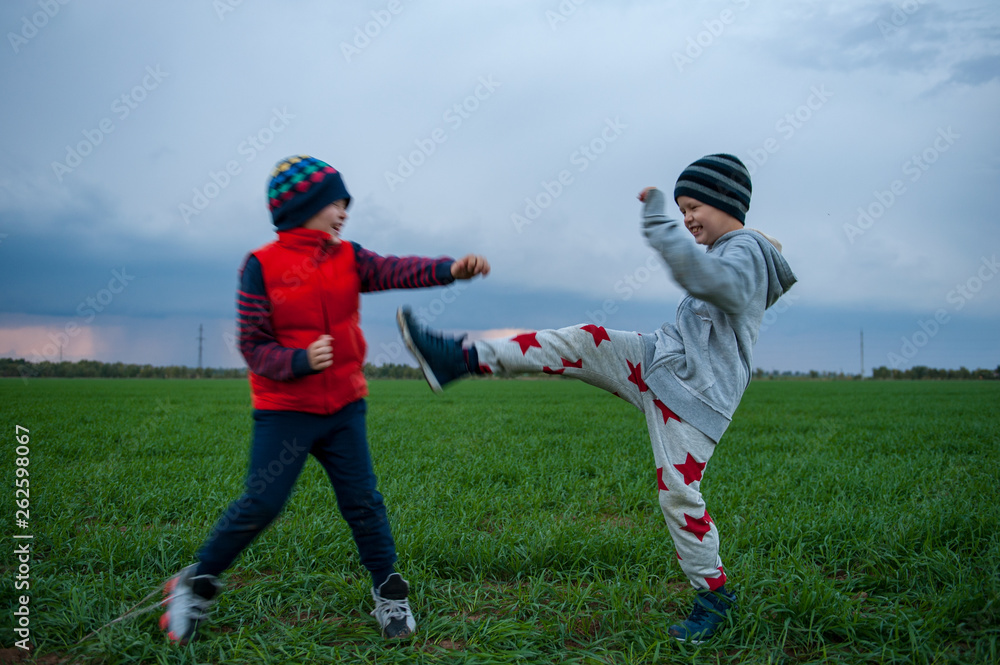happy children playing in field sown with winter wheat against backdrop ...