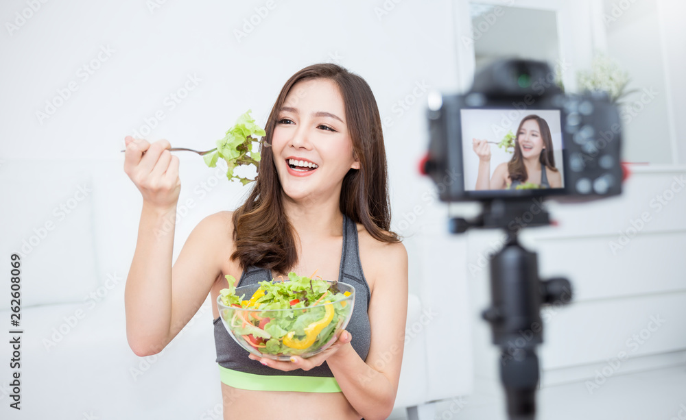 Portrait of young blogger asian woman review eating salad fan following ...