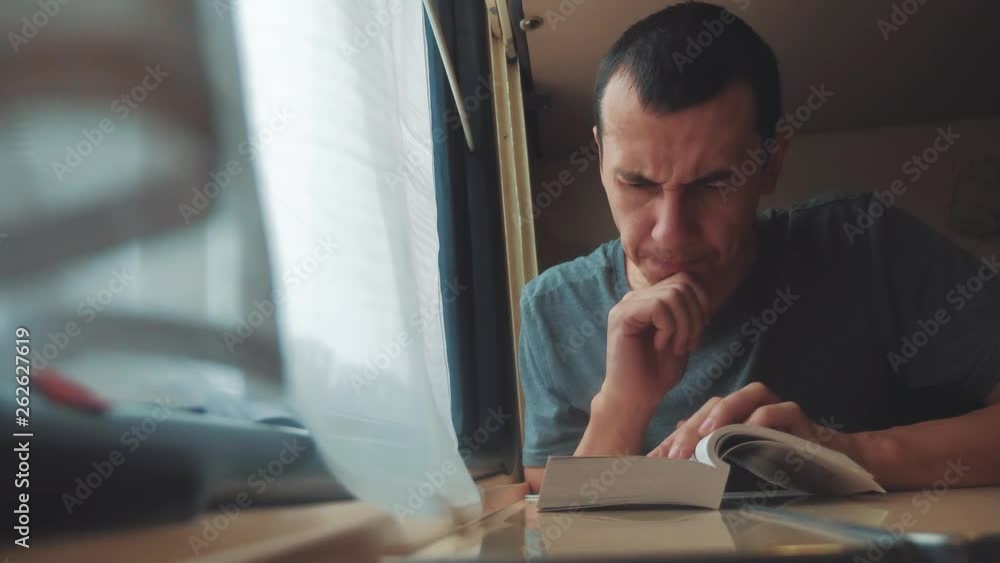 man reading a book lifestyle in a train long journey. railroad travel ...