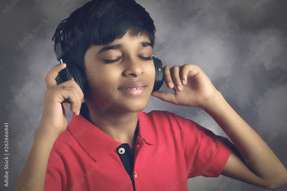 Indian young boy listen music with headphone Stock Photo | Adobe Stock
