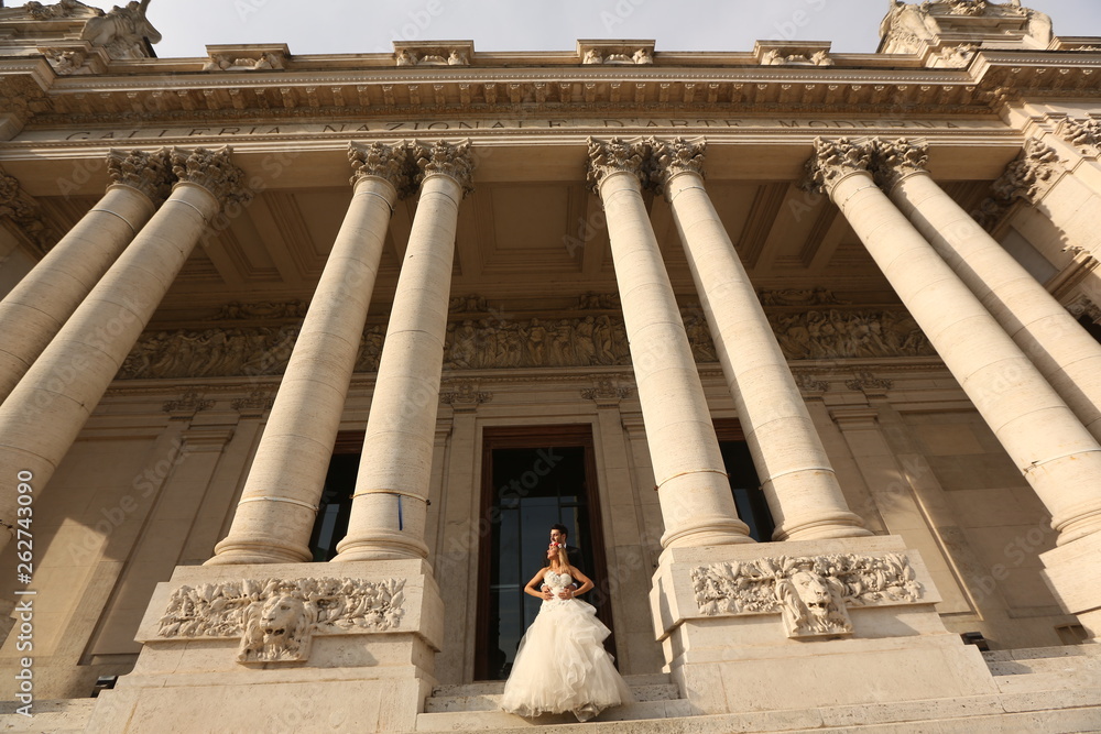 Beautiful wedding couple posing in front of old structure with columns ...