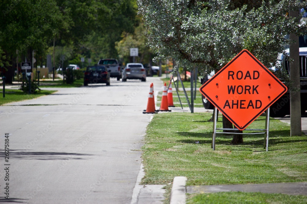 Road Work Ahead sign on metal a-frame stand with traffic cones behind ...