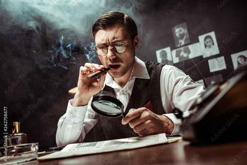 Detective in glasses smoking cigar and reading newspaper with magnifier ...