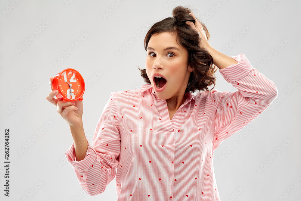 time, emotions and bedtime concept - shocked young woman in pajama with ...