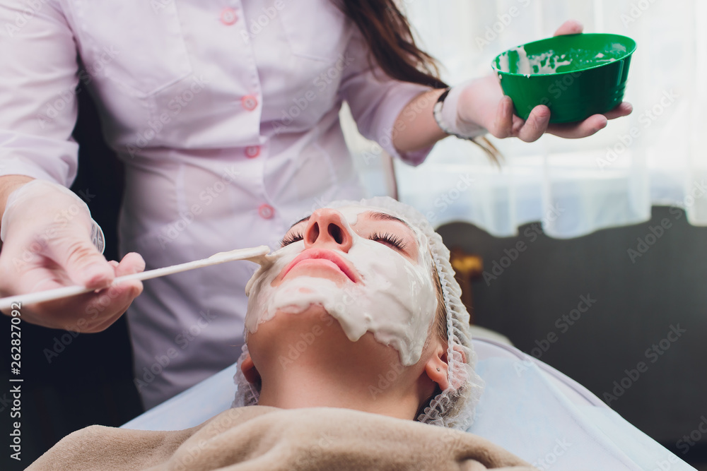 Beautiful woman having a facial cosmetic scrub treatment from ...