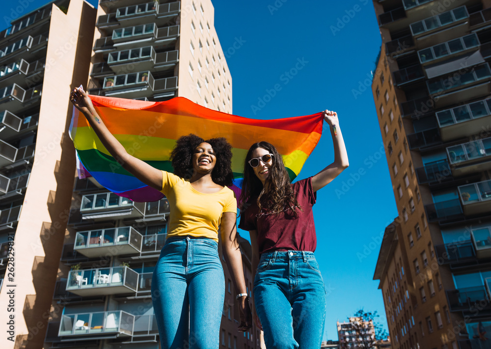Lesbian couple celebrating with LGBT flag on gay pride day Stock Photo ...