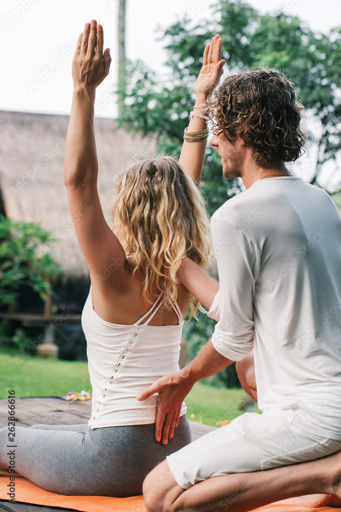 Male Yoga Teacher Helping Female Student With Posture Alignment Stock ...