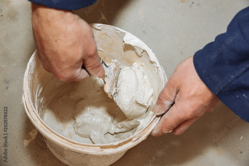Foto Stock Man is mixing spackling paste putty in the bucket. Grind of ...