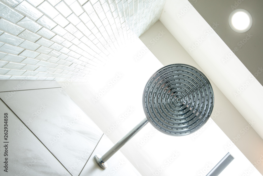 Abstract view of a showerhead towards skylight in master shower with ...