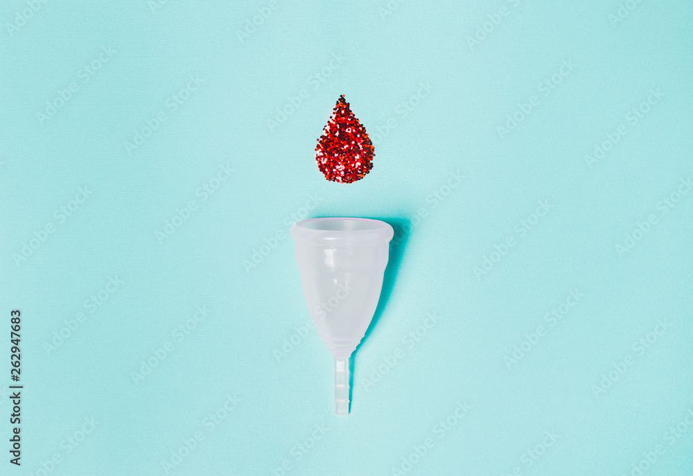 white menstrual cup with a drop of blood on a blue background Stock ...